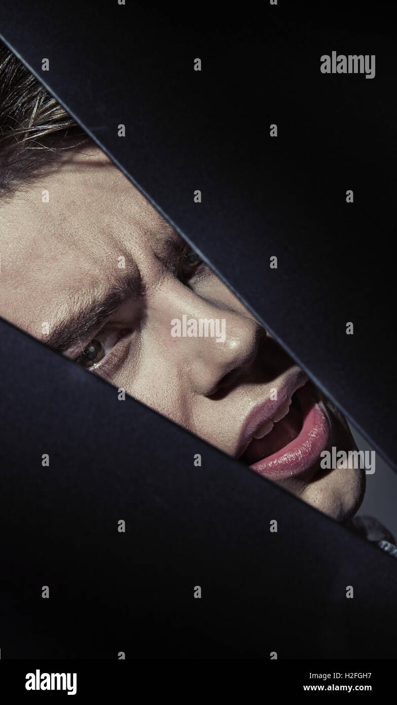 Closeup portrait of the handsome guy behind the wall Stock Photo - Alamy