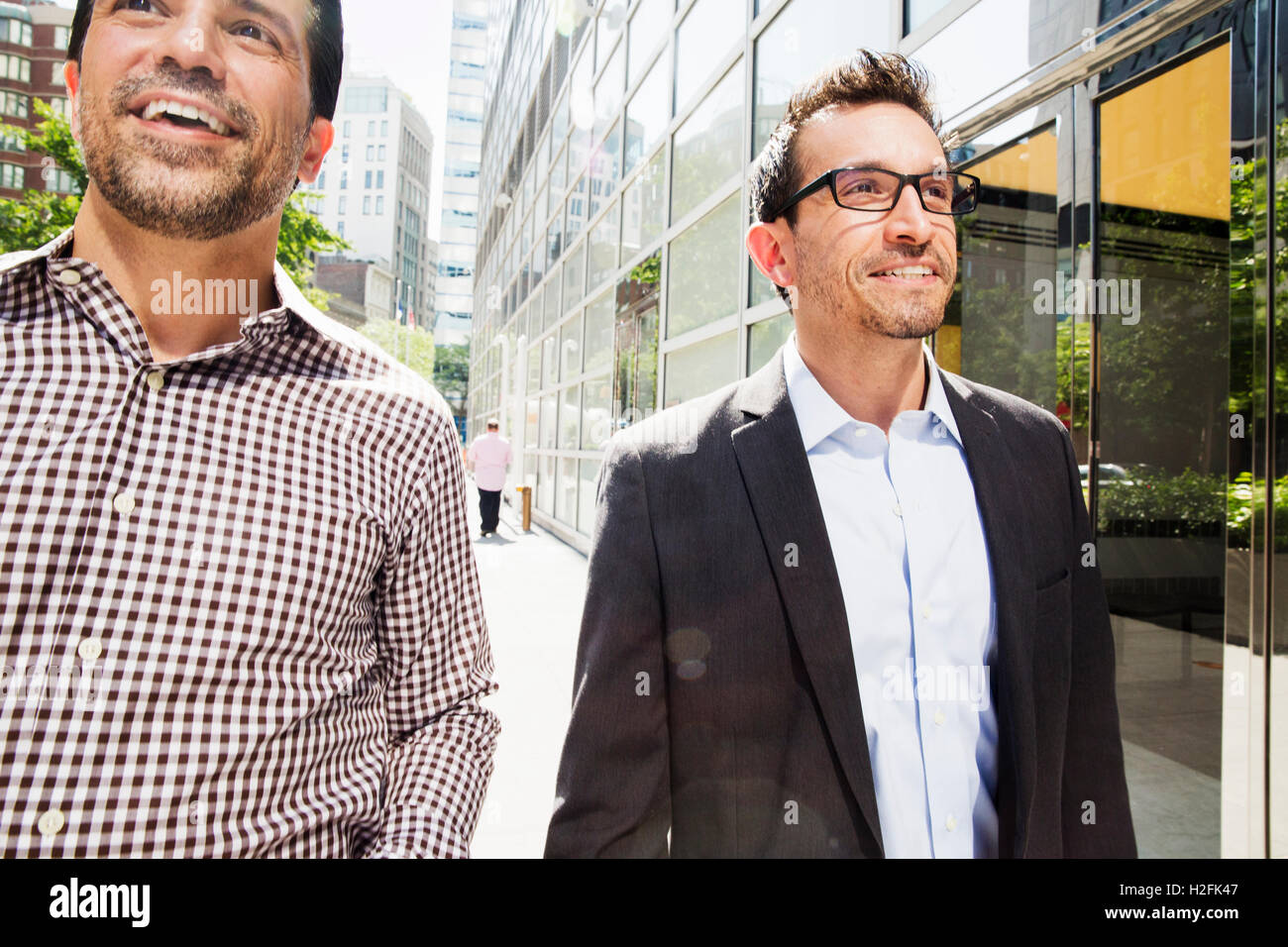 Two men walking down a city street Stock Photo - Alamy