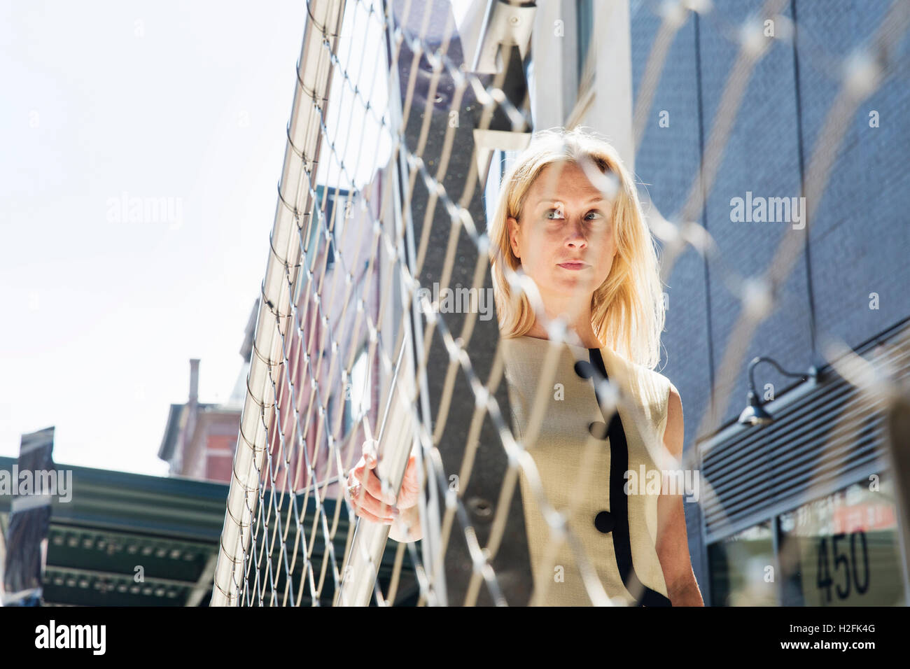 Female standing by a fence hi-res stock photography and images - Alamy
