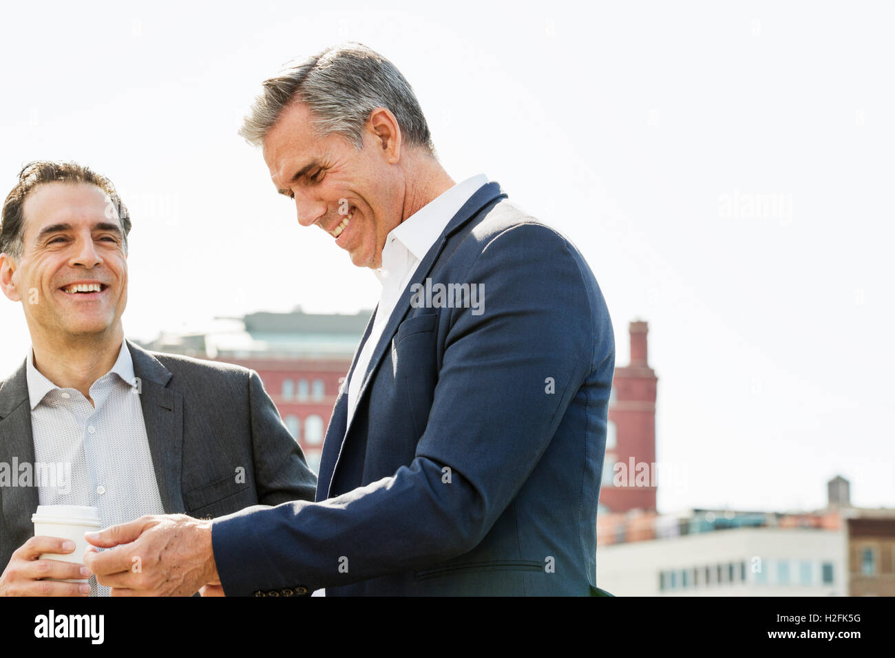Two people, men talking together outdoors, taking a coffee break Stock ...