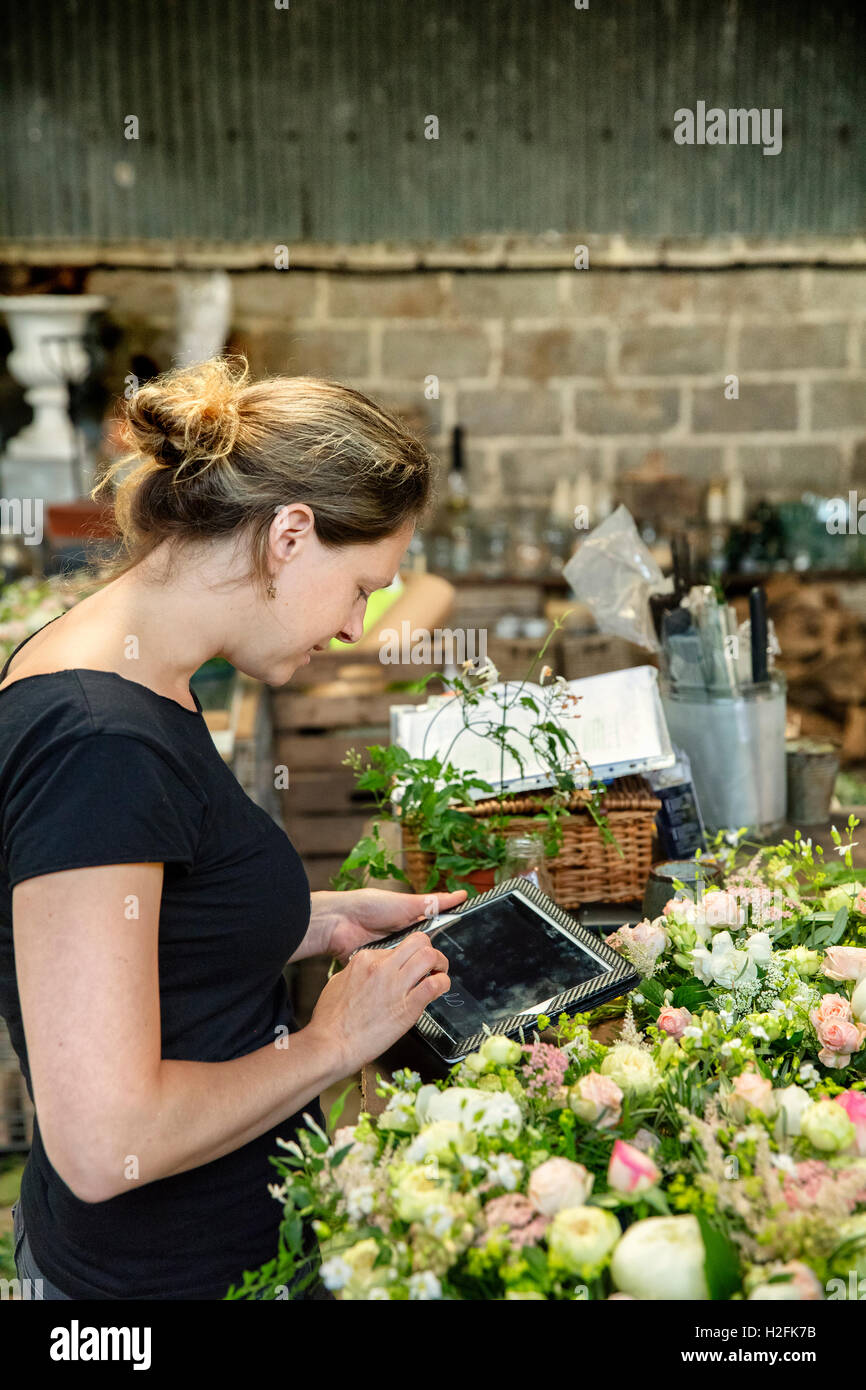 A woman florist using a digital tablet in a workshop Stock Photo - Alamy