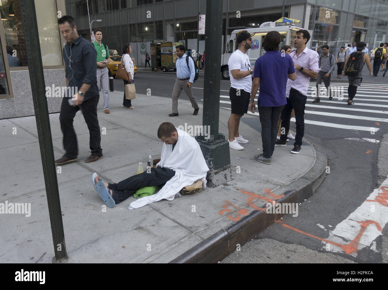 Homeless people sitting on the sidewalk begging is a common sight in ...