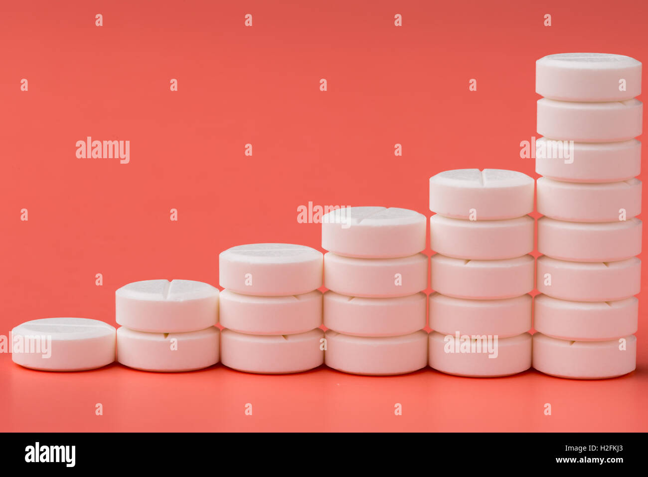 Chart from white round pills on pink background Stock Photo - Alamy