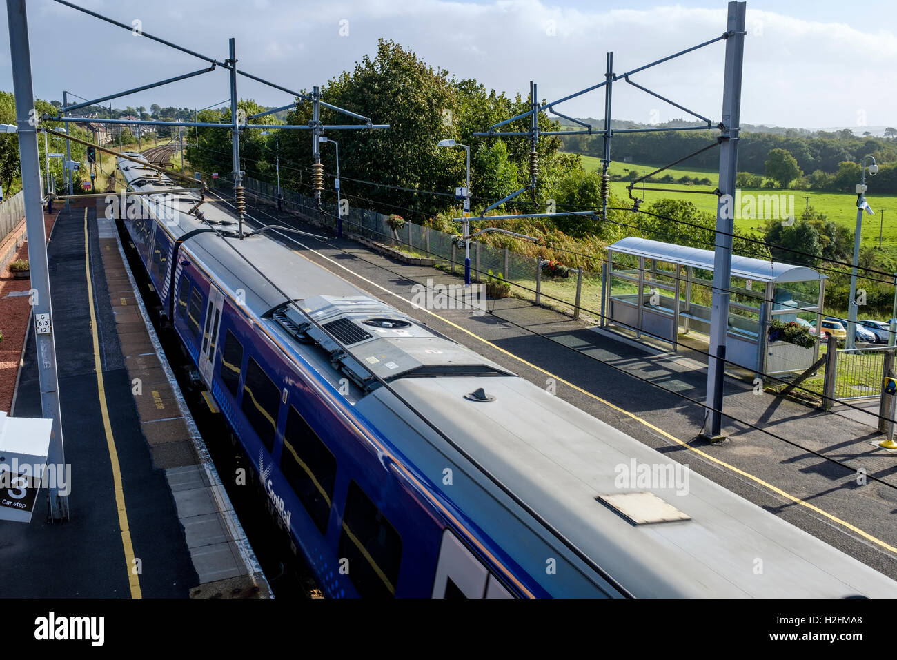 A local ScotRail commuter passenger train leaving Carluke Station in ...