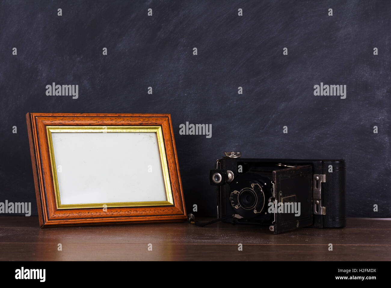 Old vintage camera and frame against blackboard background Stock Photo ...