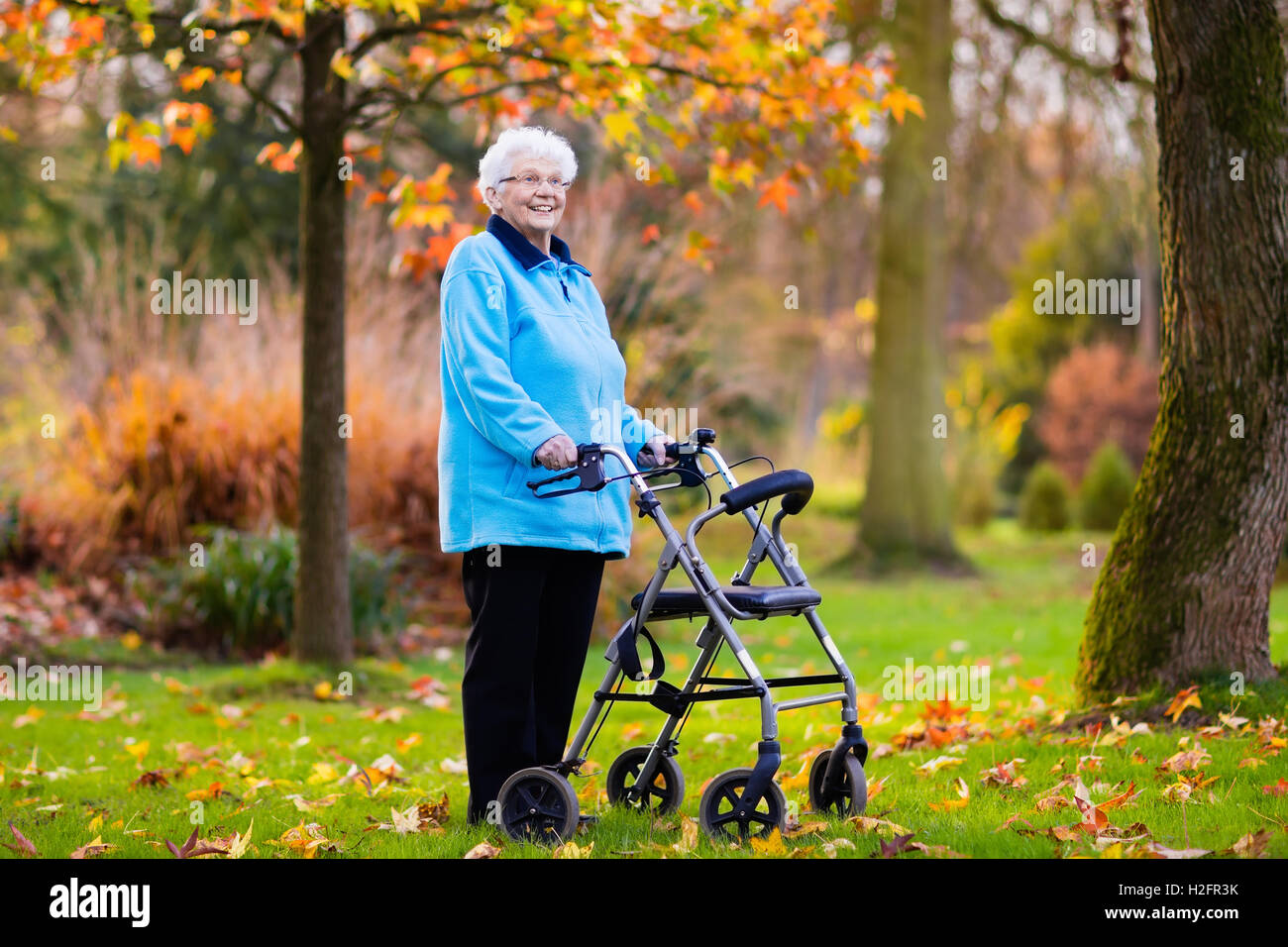 Happy senior handicapped lady with a walking disability enjoying a walk ...