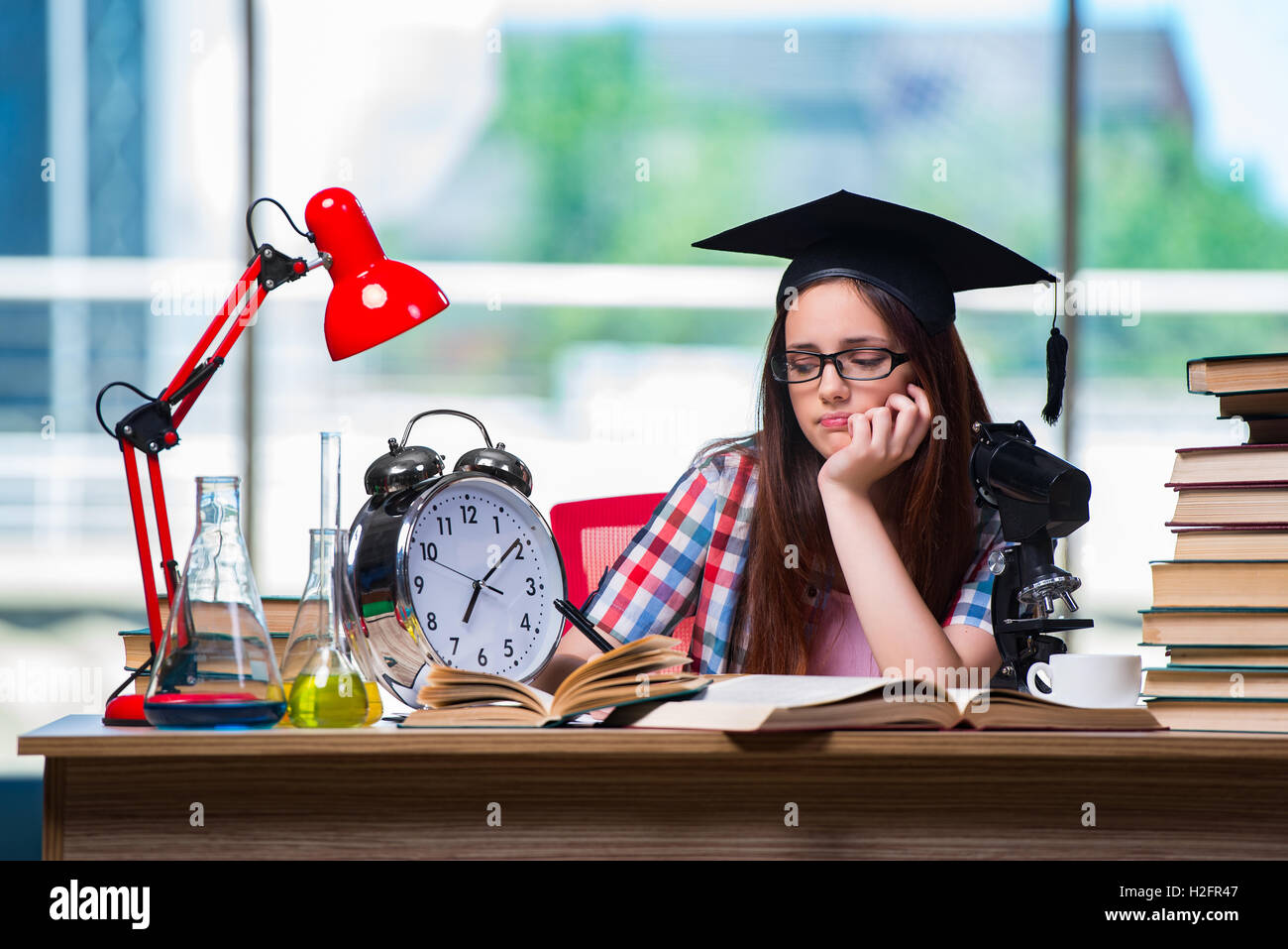 Young girl preparing for exams with large clock Stock Photo - Alamy