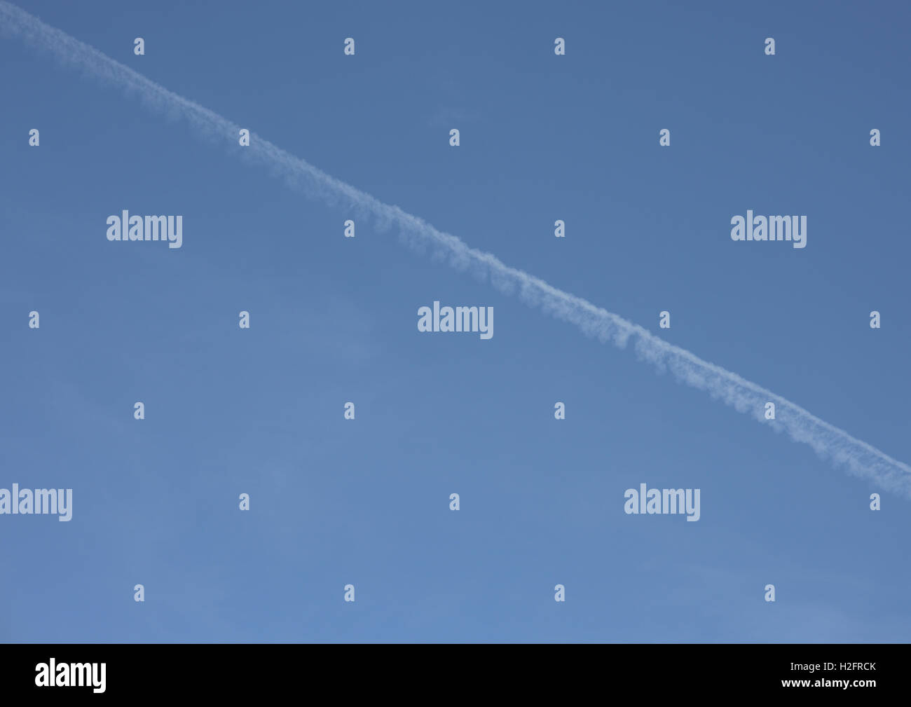 Contrail in blue sky Stock Photo - Alamy