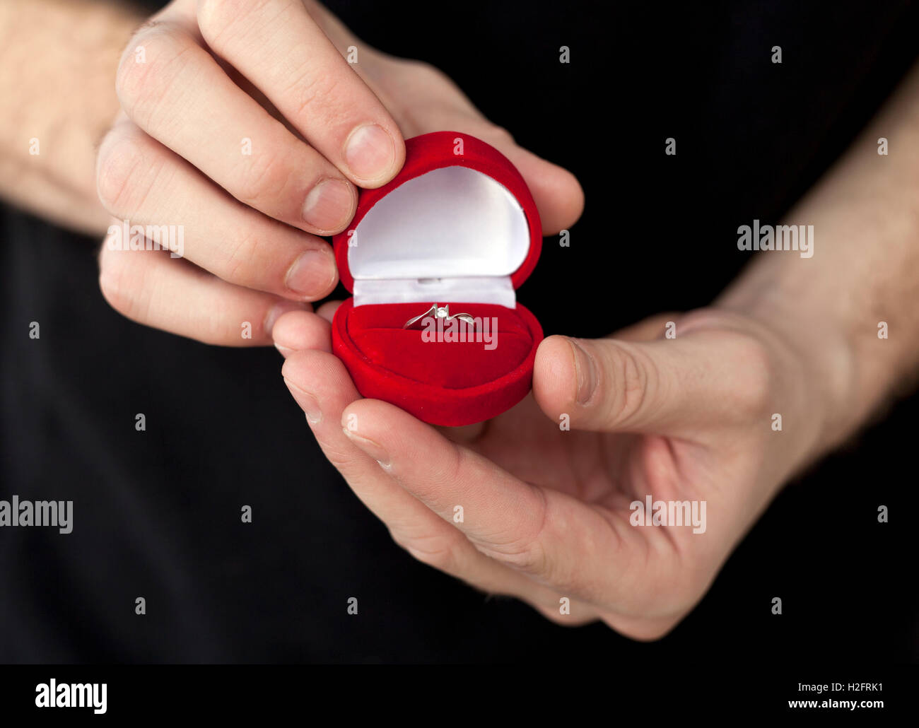 Beautiful engagement ring in red box in mans hands Stock Photo - Alamy