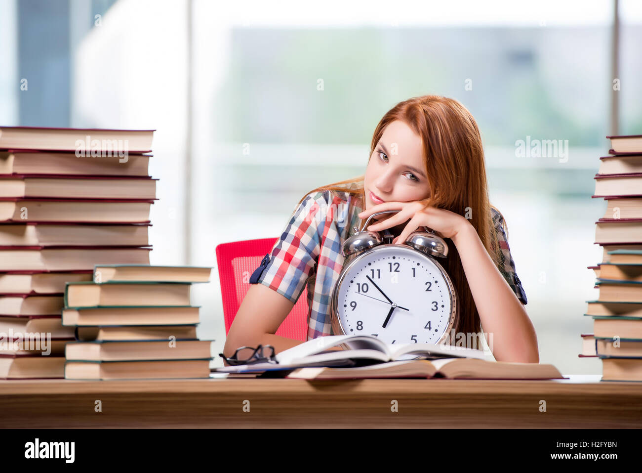 Female student with clock preparing for exams Stock Photo - Alamy