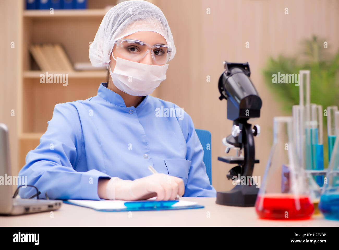 Lab chemist working with microscope and tubes Stock Photo - Alamy