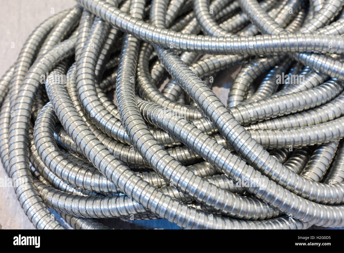 Flexible metal pipe on a background Stock Photo - Alamy