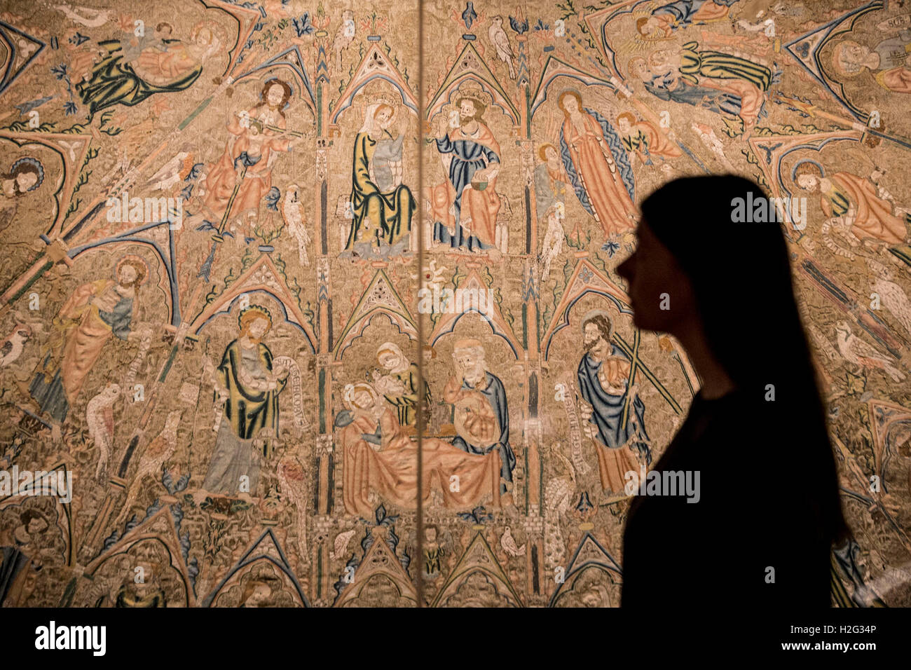 A woman looks at embroidery on display as part of the Opus Anglicanum ...