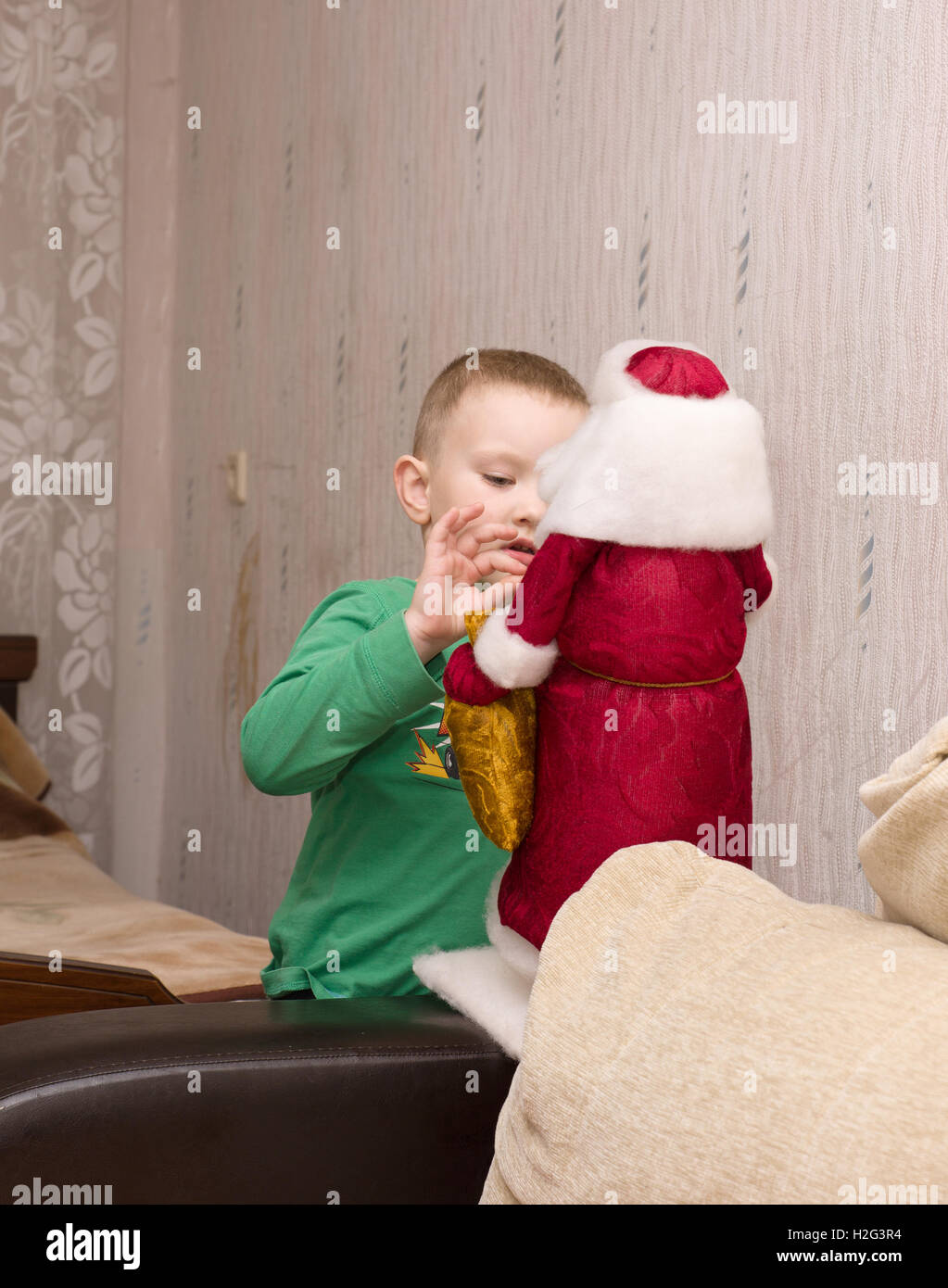 the little boy talks to a figure of Santa Claus waiting for Christmas ...