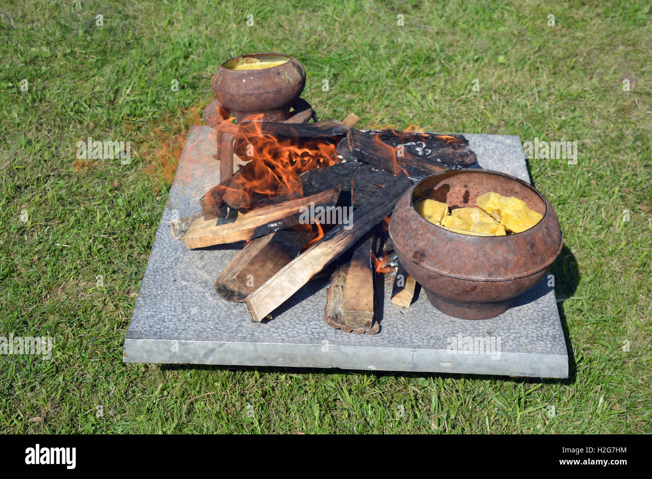 Melting wax on fire in pots for handmade candles in medieval festival ...