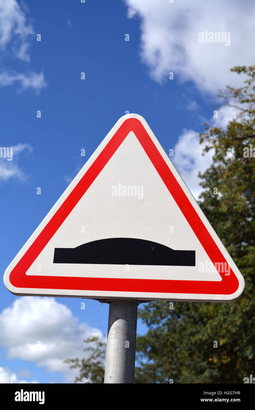 Triangle shaped road sign with red and white and black bump Stock Photo ...