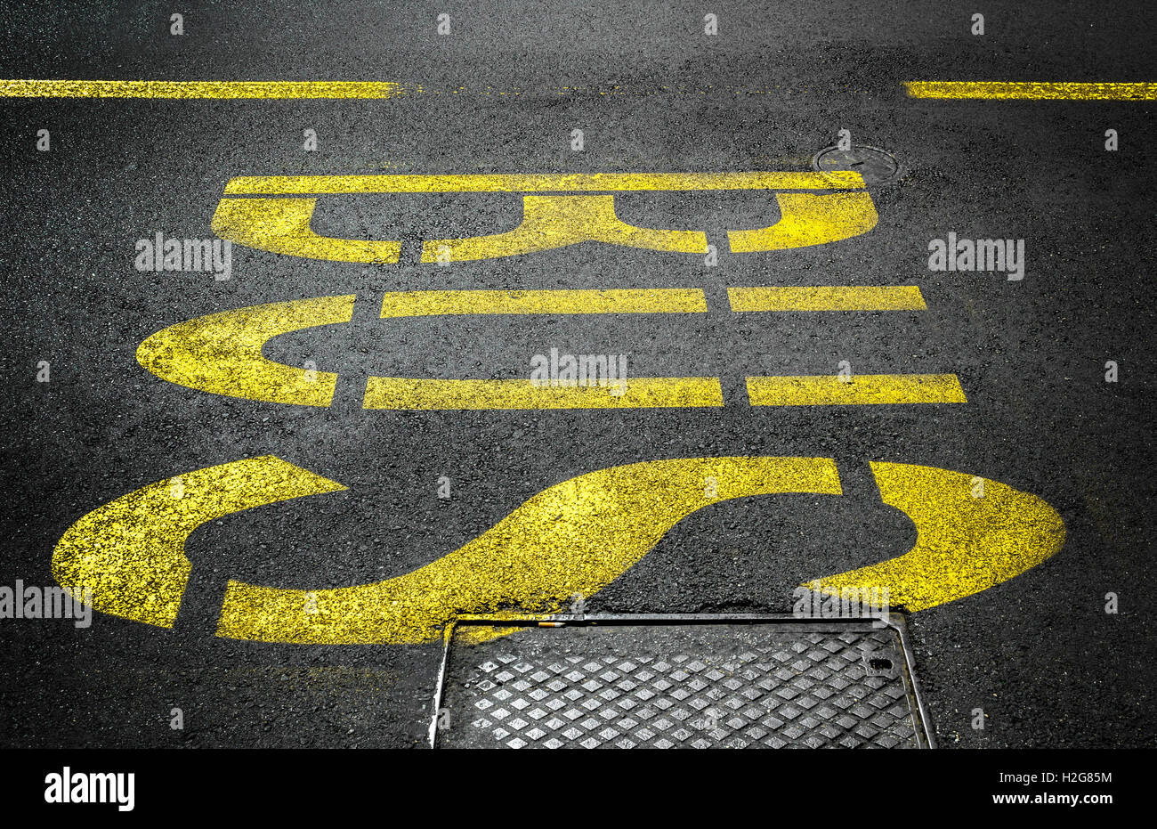 Yellow bus traffic sign painted on asphalt road Stock Photo - Alamy