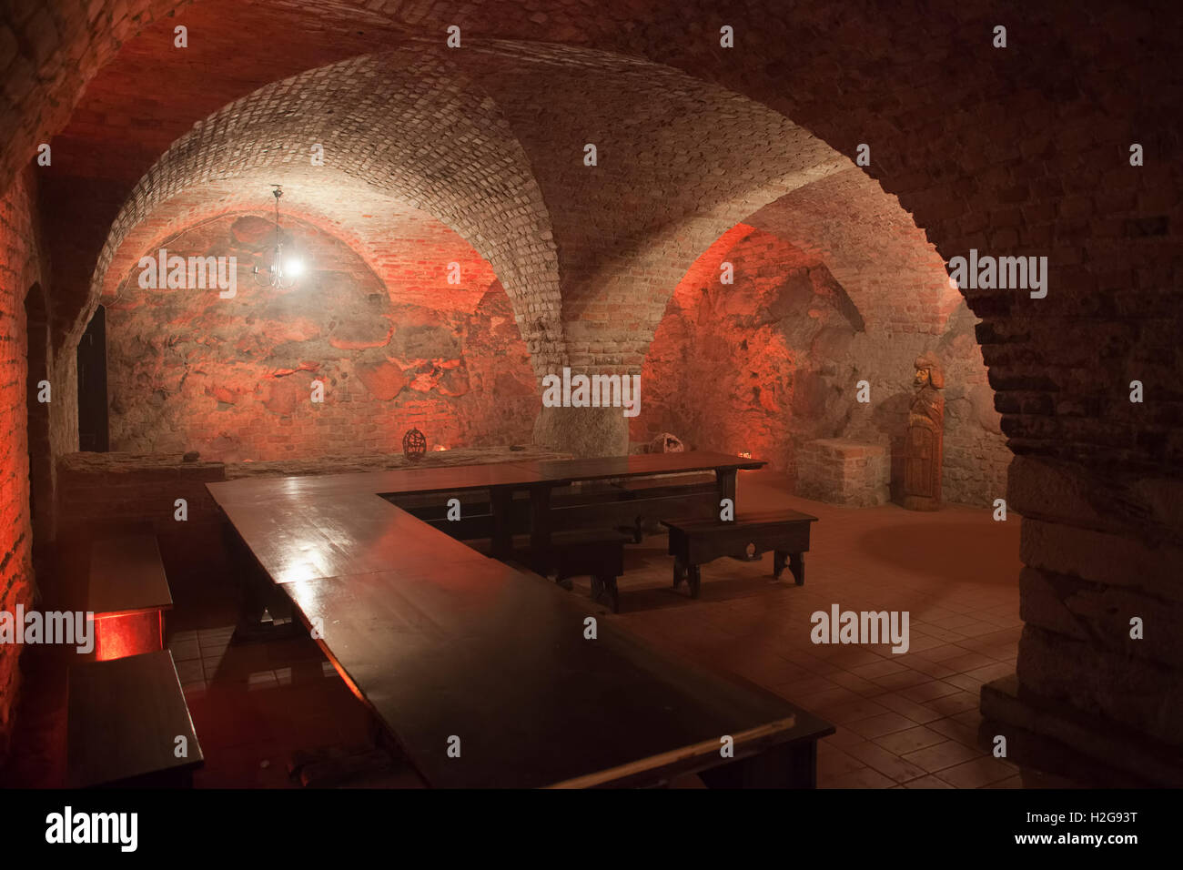 Brick arched basement, cellar with large wooden table and bench in ...