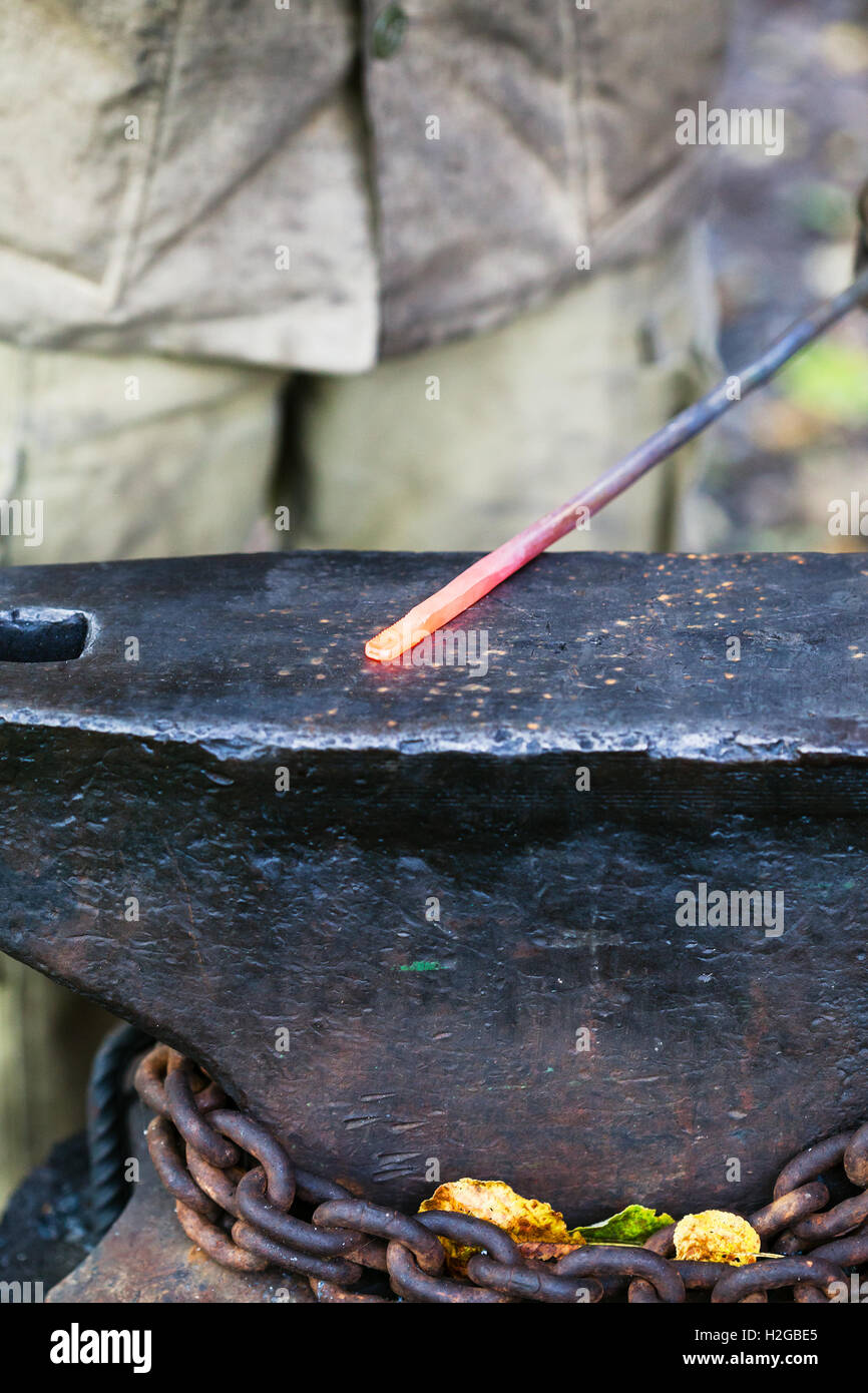 red hot glowing steel rod on anvil in outdoor rural smithy Stock Photo ...