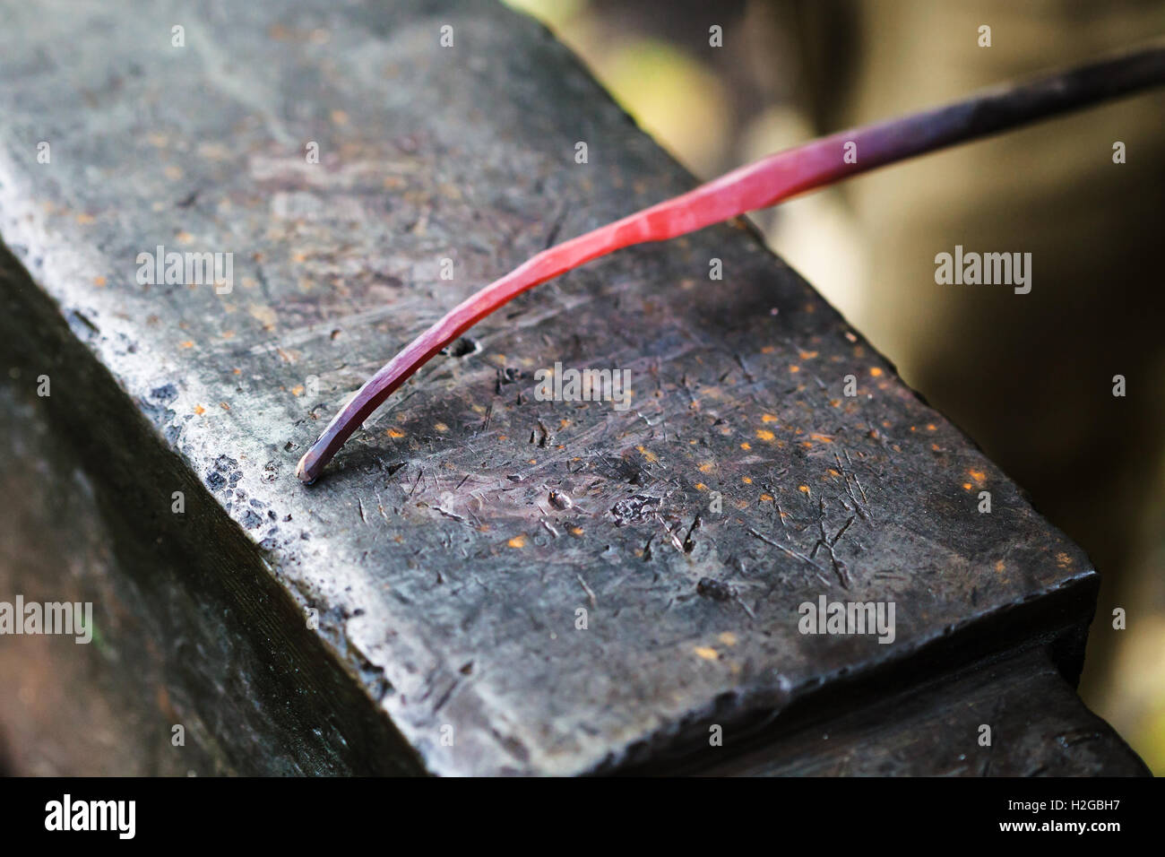 red hot glowing steel rod on anvil close up in smithy Stock Photo - Alamy
