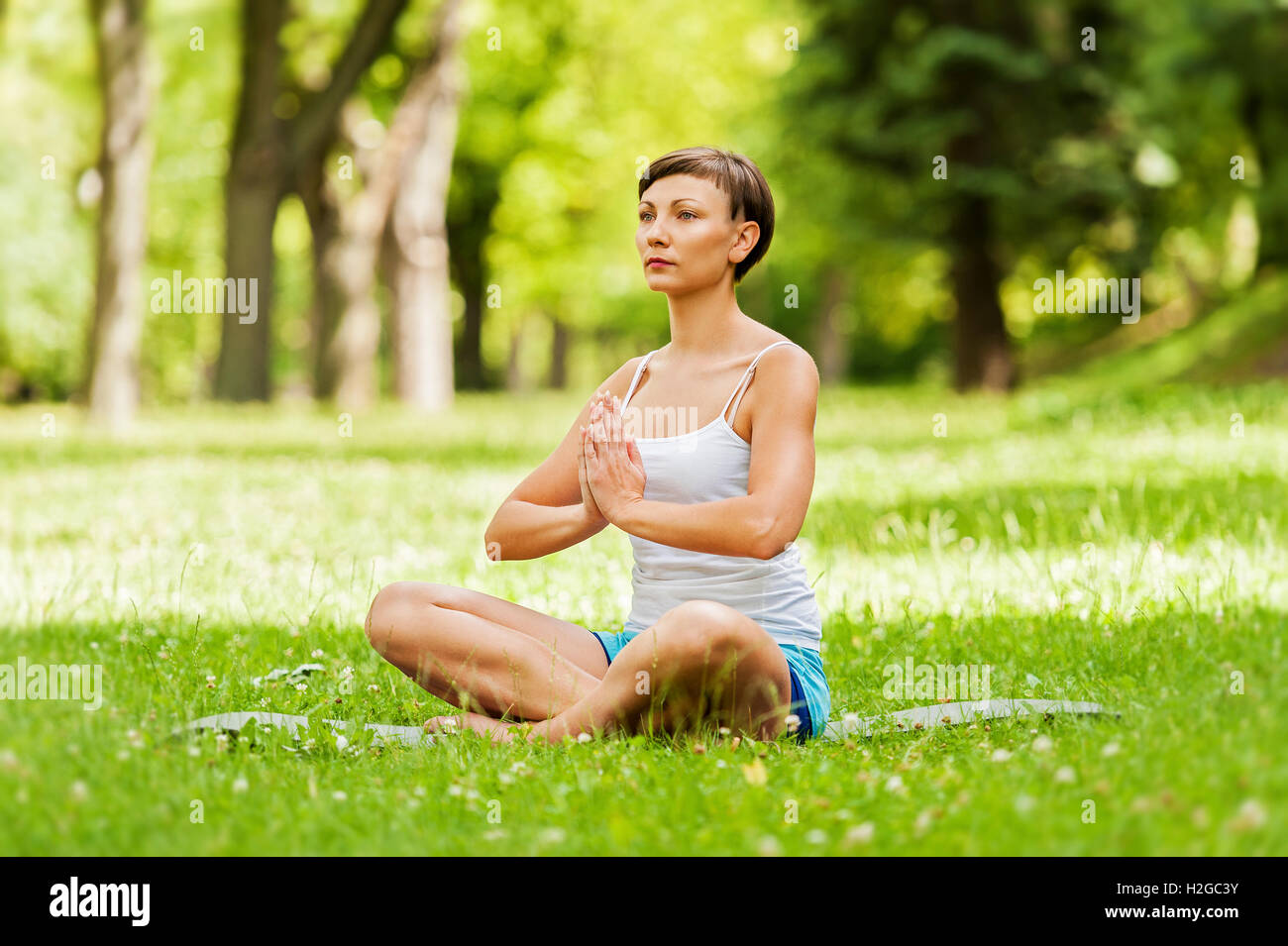 Zen yoga position woman on the grass Stock Photo - Alamy