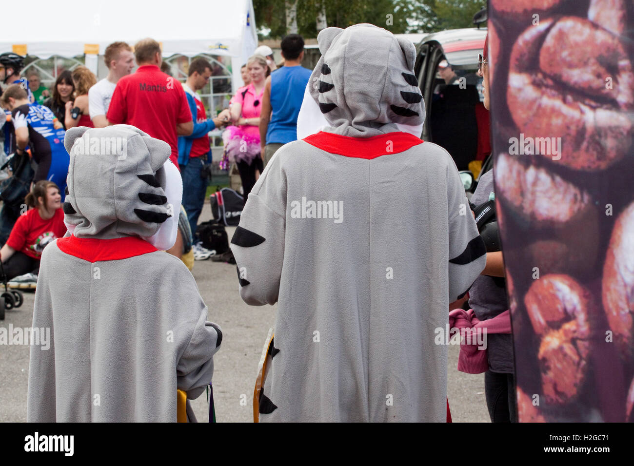Rear of two people wearing matching animal onesies at Goodwood Motor ...
