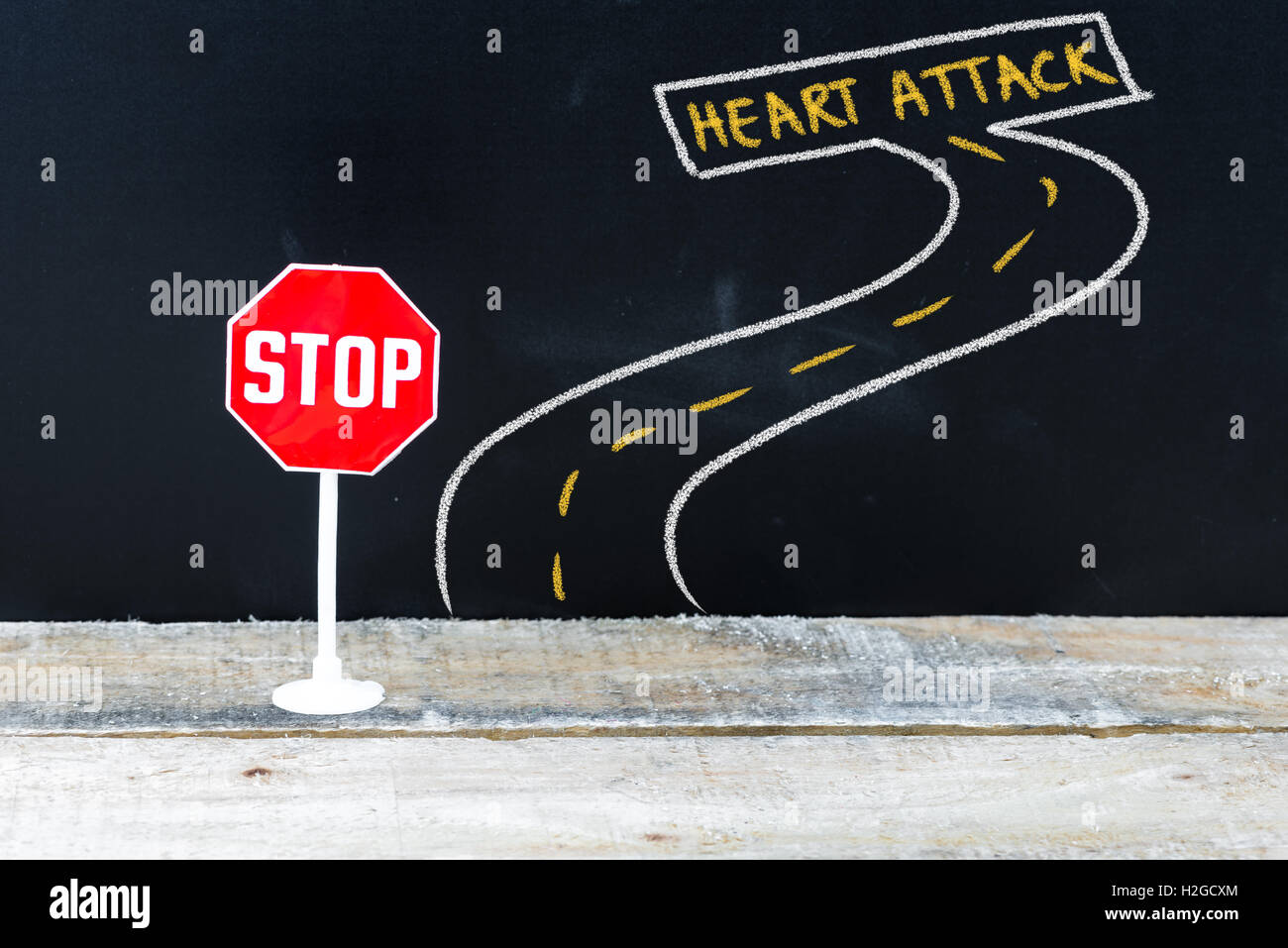 Mini STOP sign on the road to HEART ATTACK, hand drawing over ...