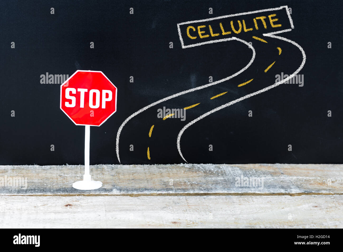 Mini STOP sign on the road to CELLULITE, hand drawing over chalkboard ...