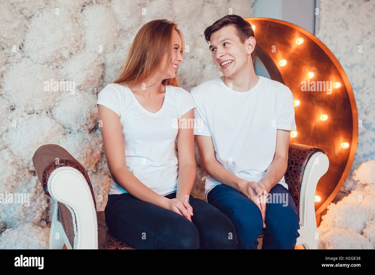 Young couple sitting and having fun at home Stock Photo - Alamy