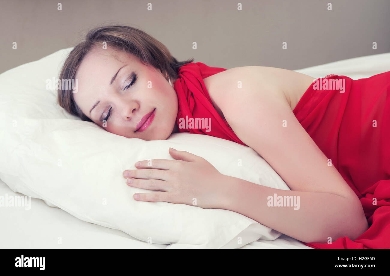 woman with red dress relaxing in bed Stock Photo - Alamy