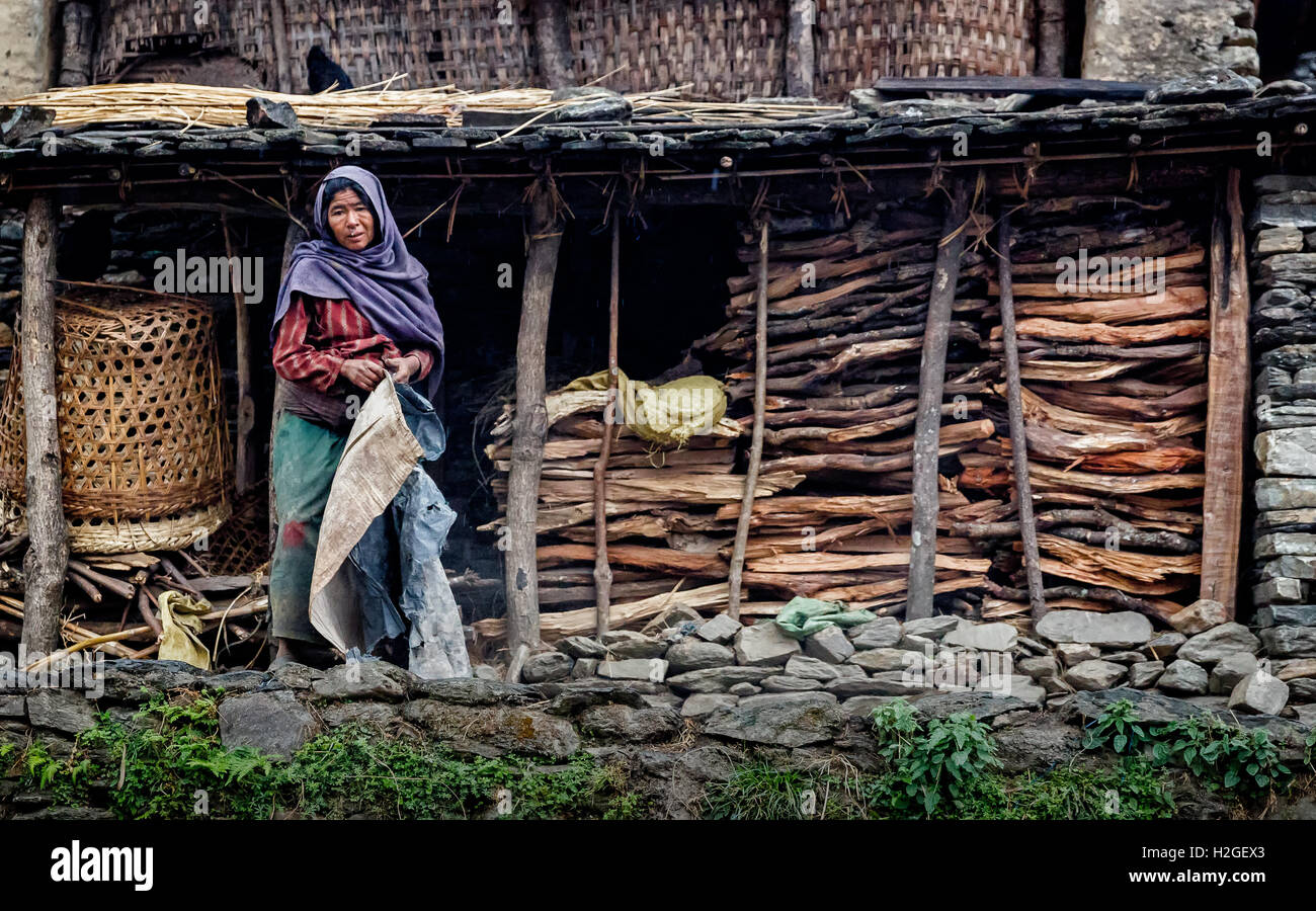 Woman rests outside her home in a mountain village in Nepal after ...