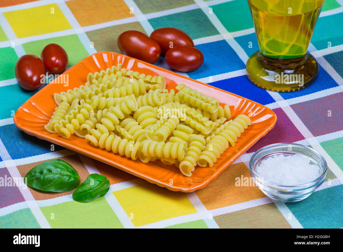 Uncooked pasta in an orange ceramic tray Stock Photo - Alamy