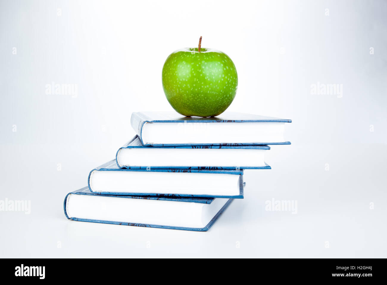 stack of books with green apple Stock Photo - Alamy