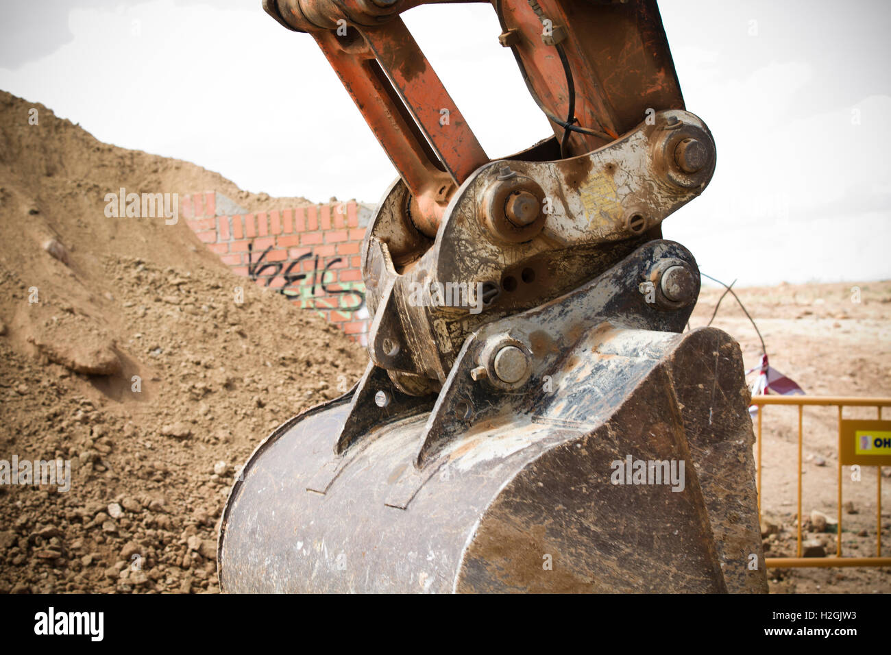 Excavator standing in sandpit with raised bucket over cloudscape Stock ...
