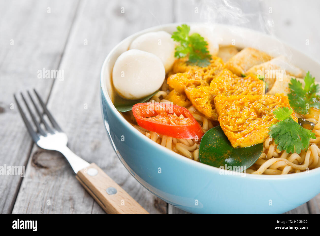 Spicy curry instant noodles with fork Stock Photo - Alamy