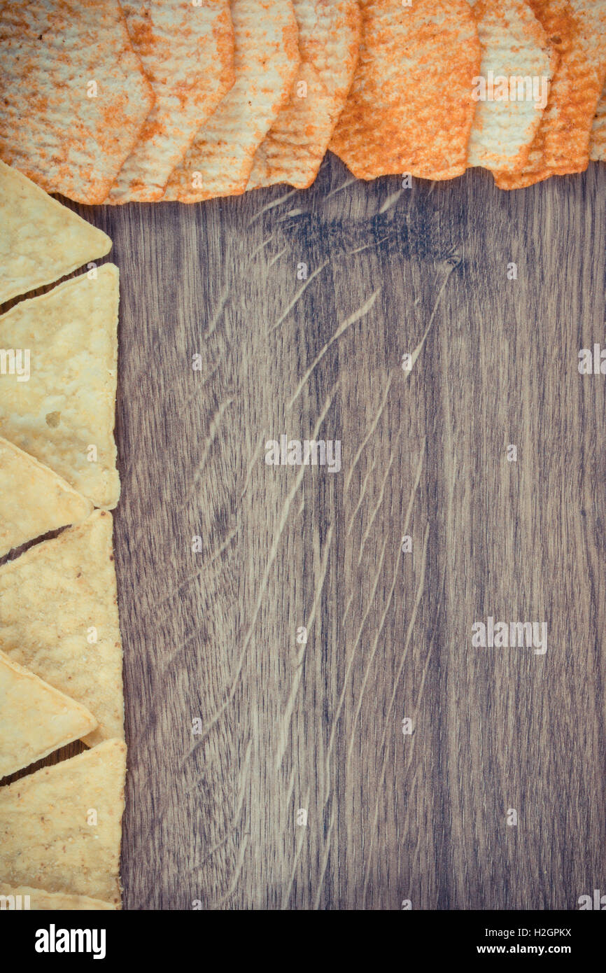 Vintage photo, Frame of salty potato crisps on rustic board, concept of ...
