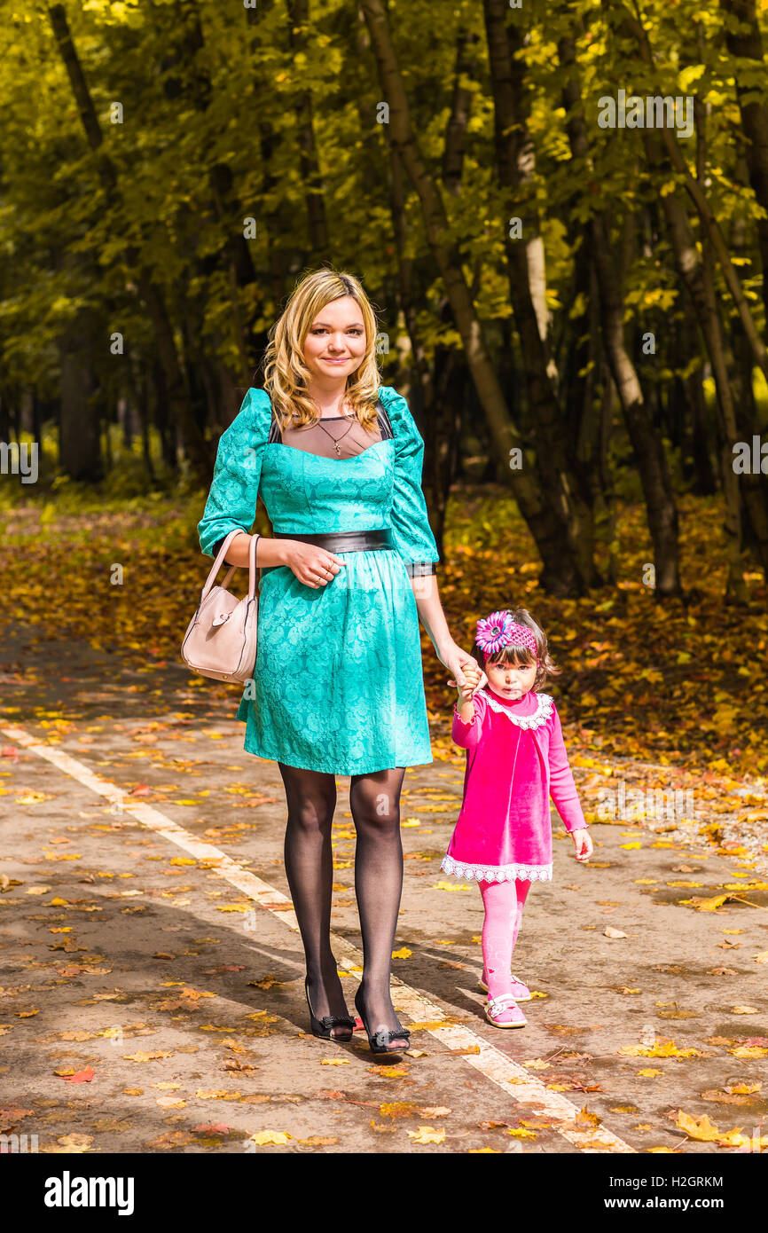 Mother and daughter walking holding hands at park. Family lifestyle, autumn season concept Stock ...