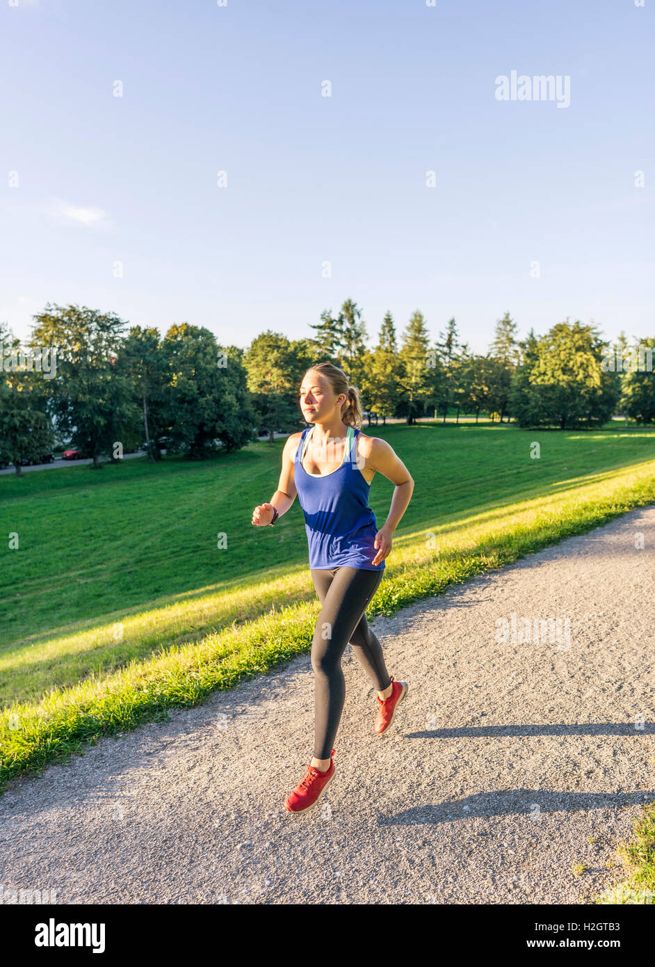 Young woman in sportswear jogging in park, Munich, Upper Bavaria ...