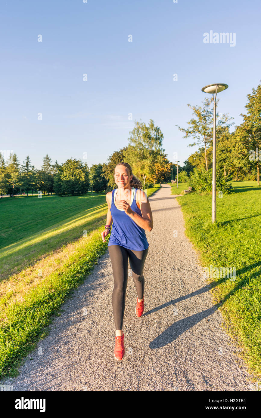 Young woman in sportswear jogging in park, Munich, Upper Bavaria ...