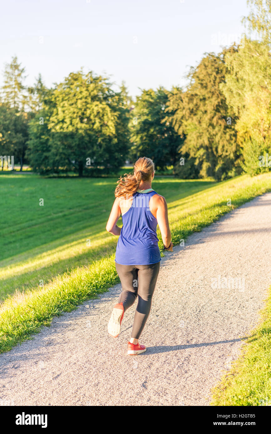 Young woman in sportswear jogging in park, Munich, Upper Bavaria ...