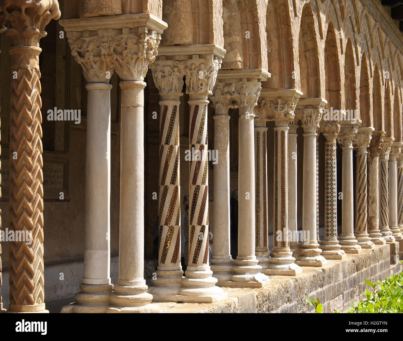 Cloister with ornate pillars in the courtyard of Monreale Cathedral ...