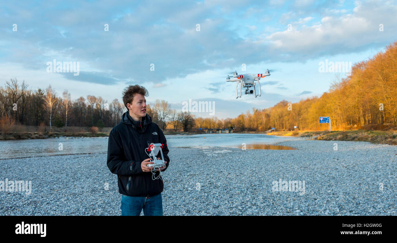 Young man controlling quadcopter, drone with camera flying, DJI Phantom ...