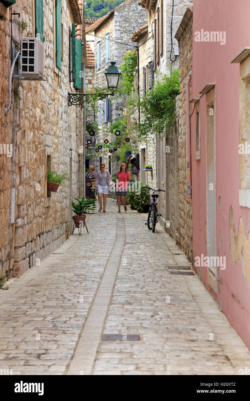 Tourists explore a narrow old street, Stari Grad, Hvar Island, Croatia ...