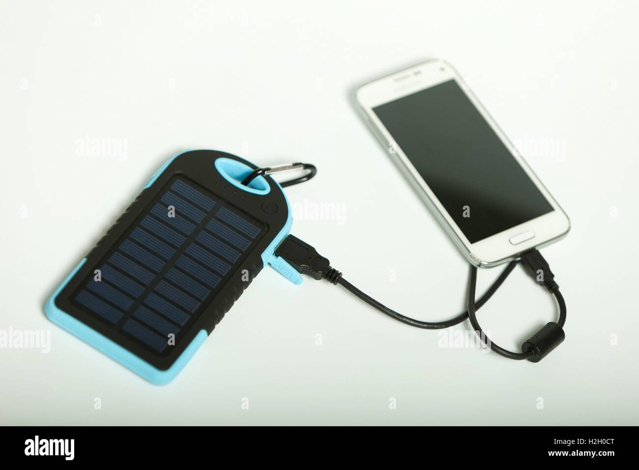 product photo of a portable solar cell powerbank charging a cell phone ...