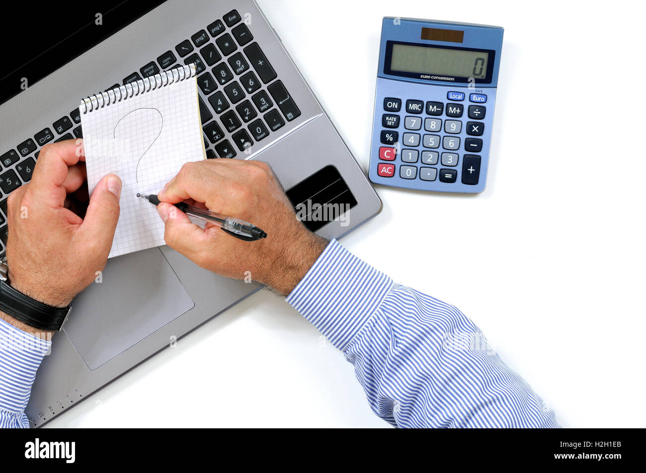 Top view of a man writing on a notepad on the desk in a modern office ...