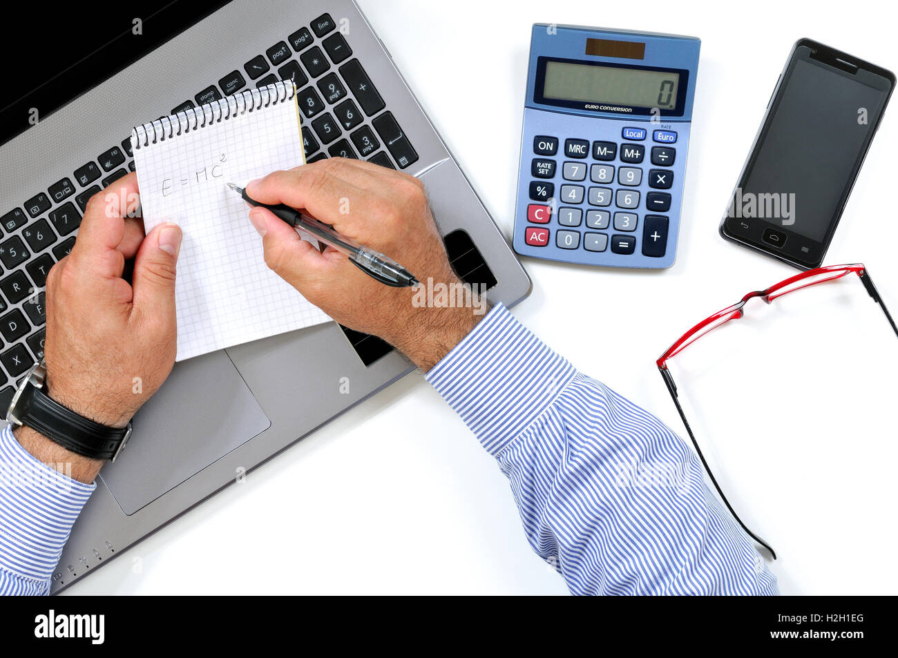 Top view of a man writing on a notepad on the desk in a modern office ...
