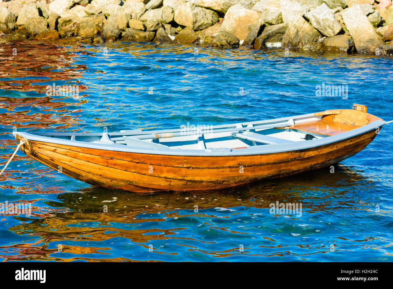 Small wooden rowboat moored close to stone pier Stock Photo - Alamy