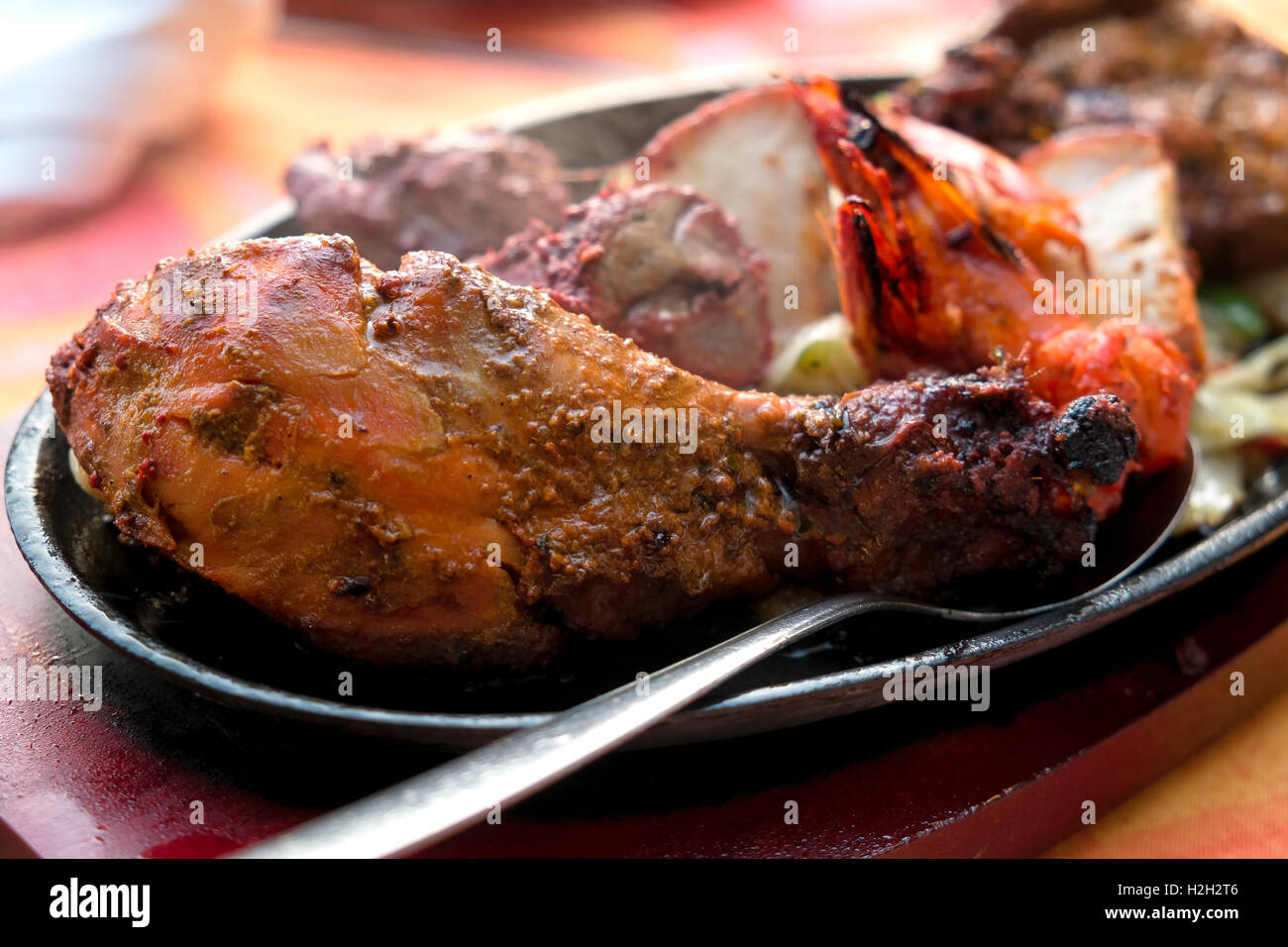 A dish of indian food at a restaurant. Steam coming of the plate which ...
