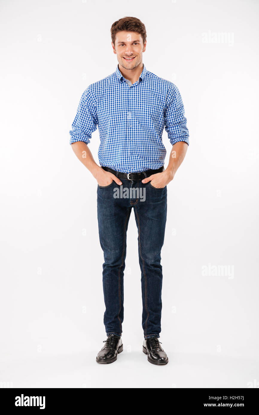 Full length of handsome smiling young man standing over white ...