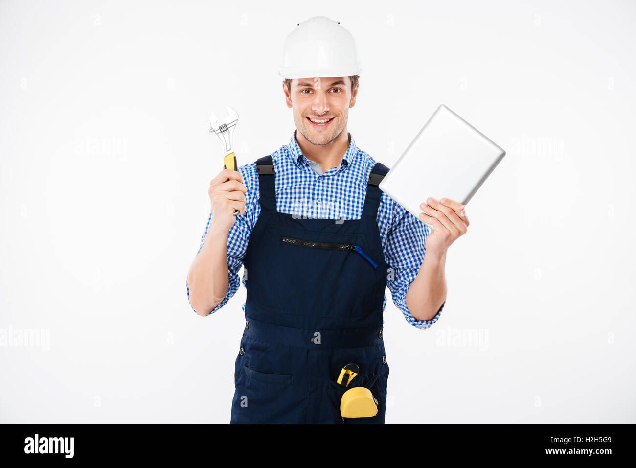 Happy male builder showing thumb up and holding pc tablet isolated on a ...
